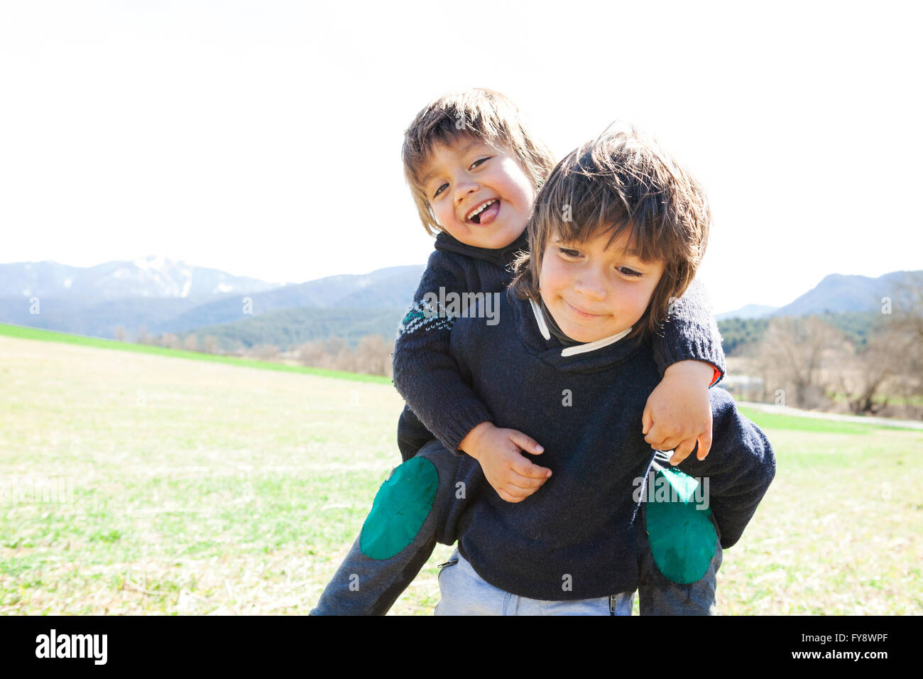 Portrait of little boy carrying his brother piggyback Stock Photo - Alamy