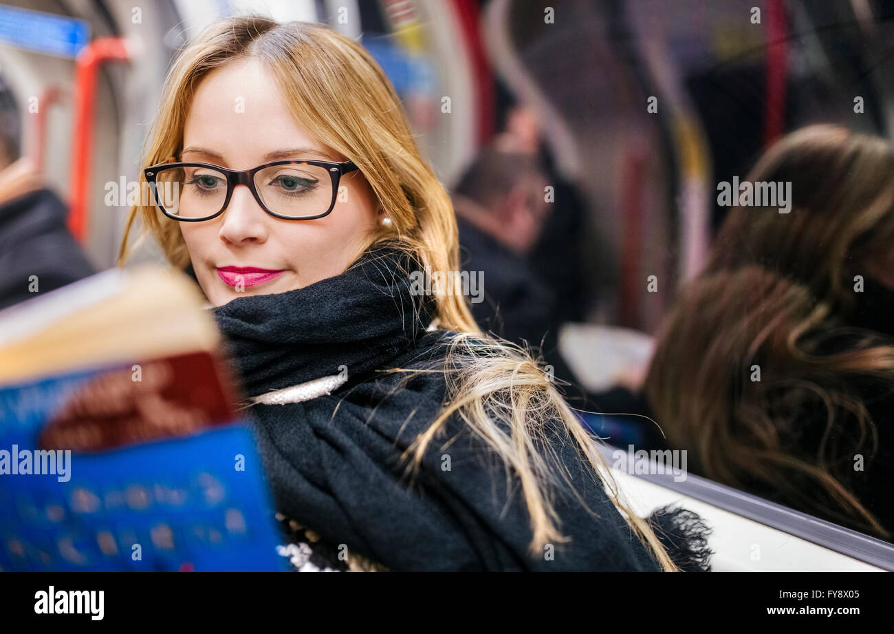 Young woman reading on the subway Stock Photo - Alamy
