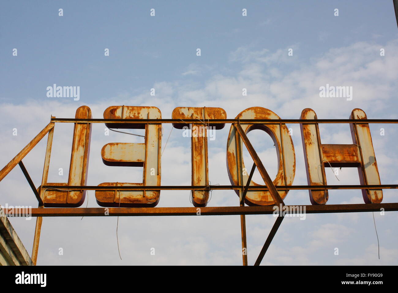 Rusty Hotel Sign against blue sky, inverted Stock Photo - Alamy