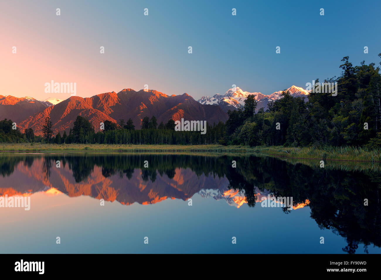 Twin Peaks reflect in the beautiful Lake Matheson at sunset, Southern ...
