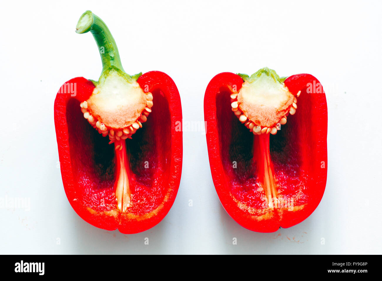 Cut half of a red pepper on a white background Stock Photo - Alamy