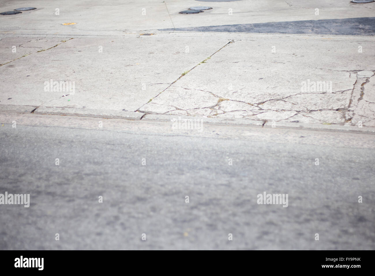 Broken sidewalk with metal caps and cracks Stock Photo - Alamy