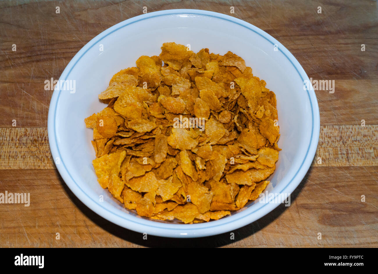 White bowl of dry corn flakes on brown wood table Stock Photo - Alamy