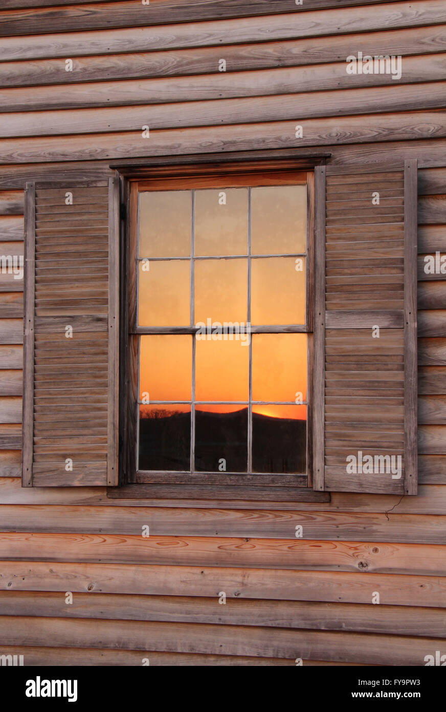 Sunset reflected in window of wooden house Stock Photo - Alamy