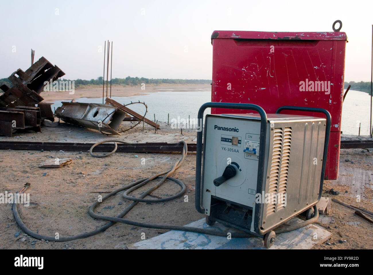 A generator on a bridge being built to replace a bamboo bridge that ...