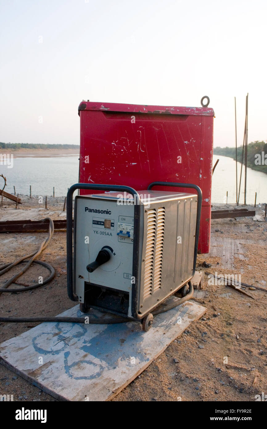 A generator on a bridge being built to replace a bamboo bridge that ...