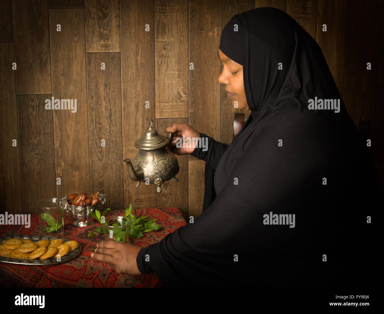 Smiling muslim woman pouring mint tea the traditional way Stock Photo ...