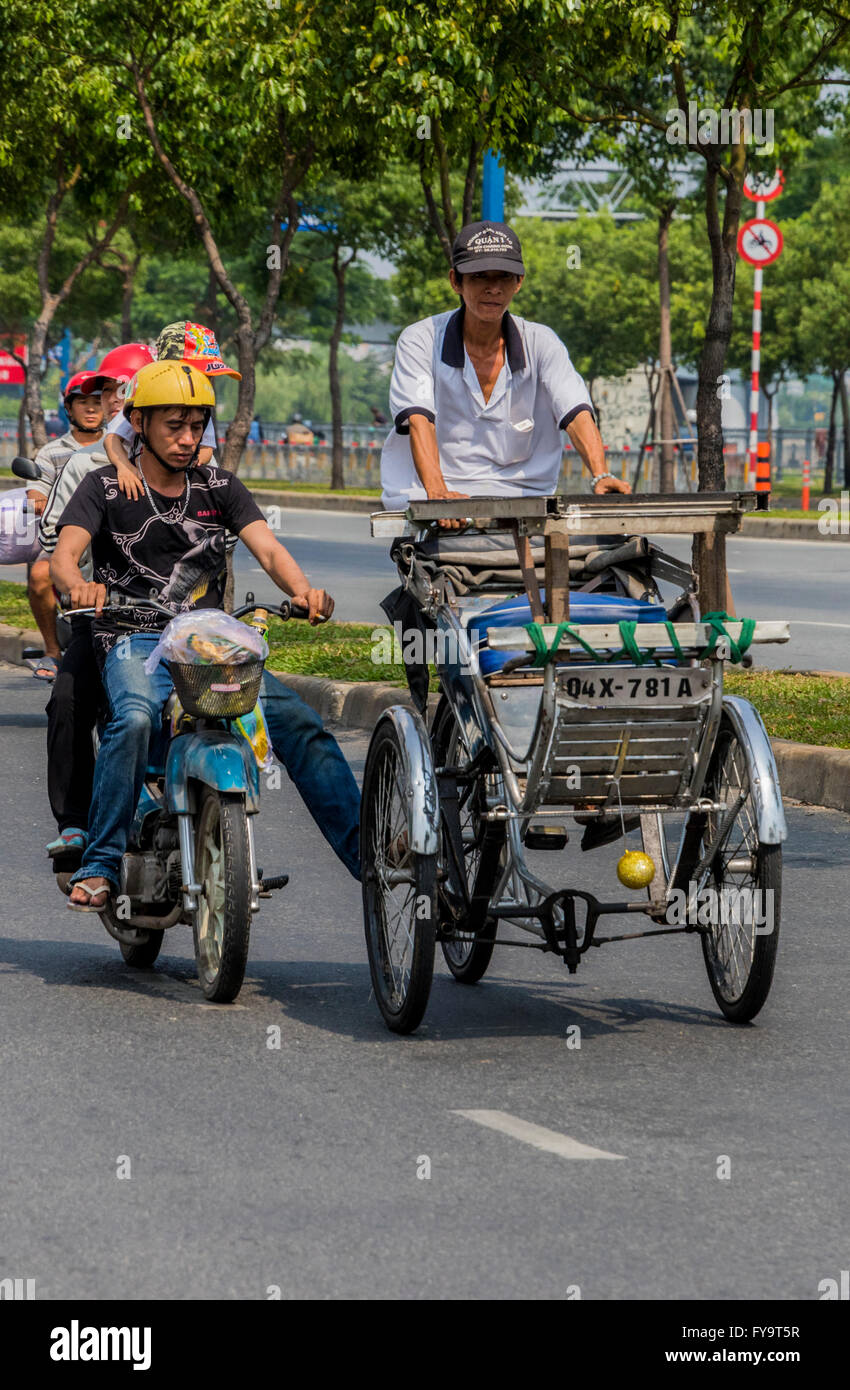 Cyclo taxi in Ho Chi Minh city Vietnam being pushed along road by small ...