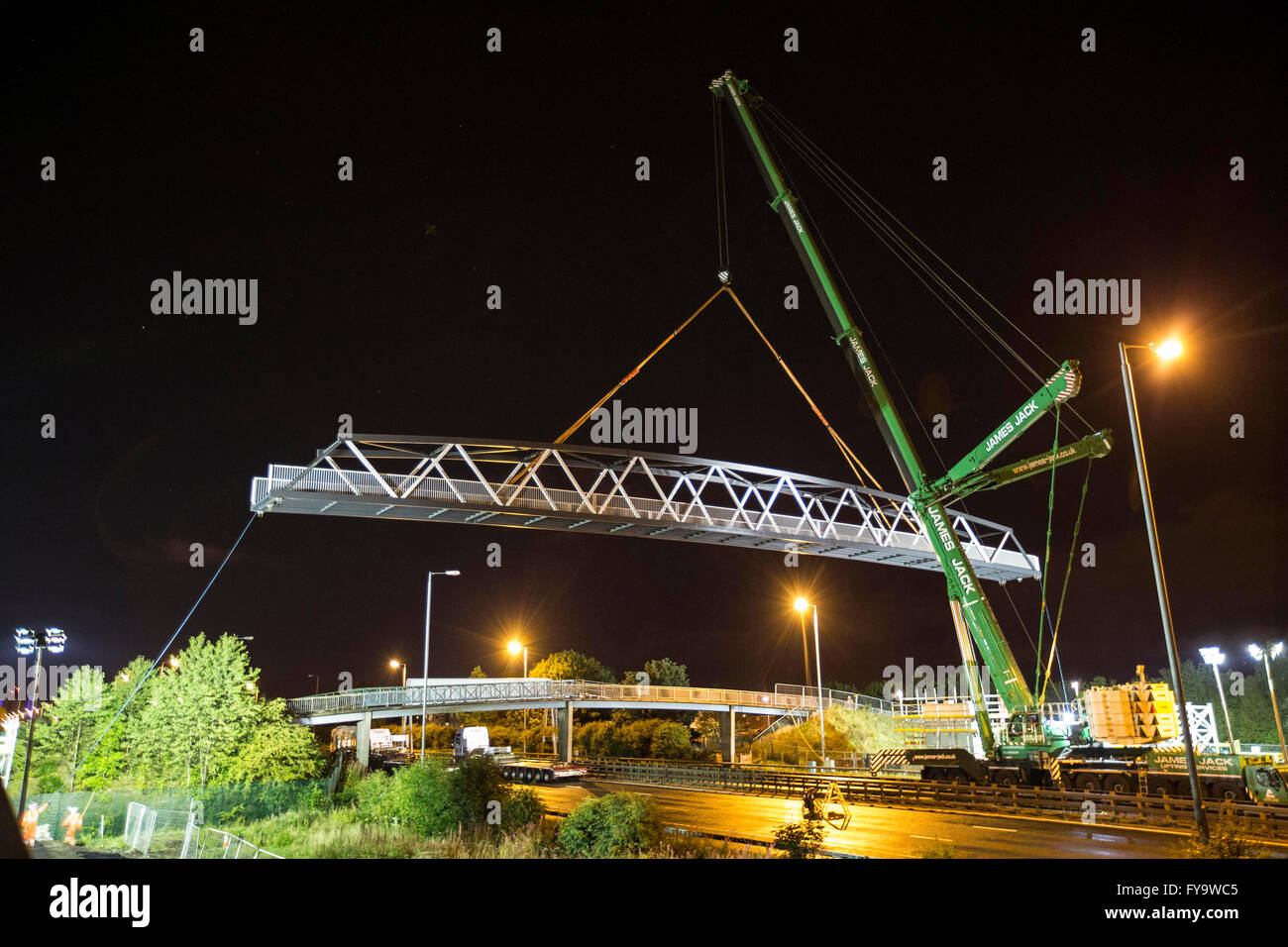 Footbridge being lifted in at night by crane Stock Photo - Alamy