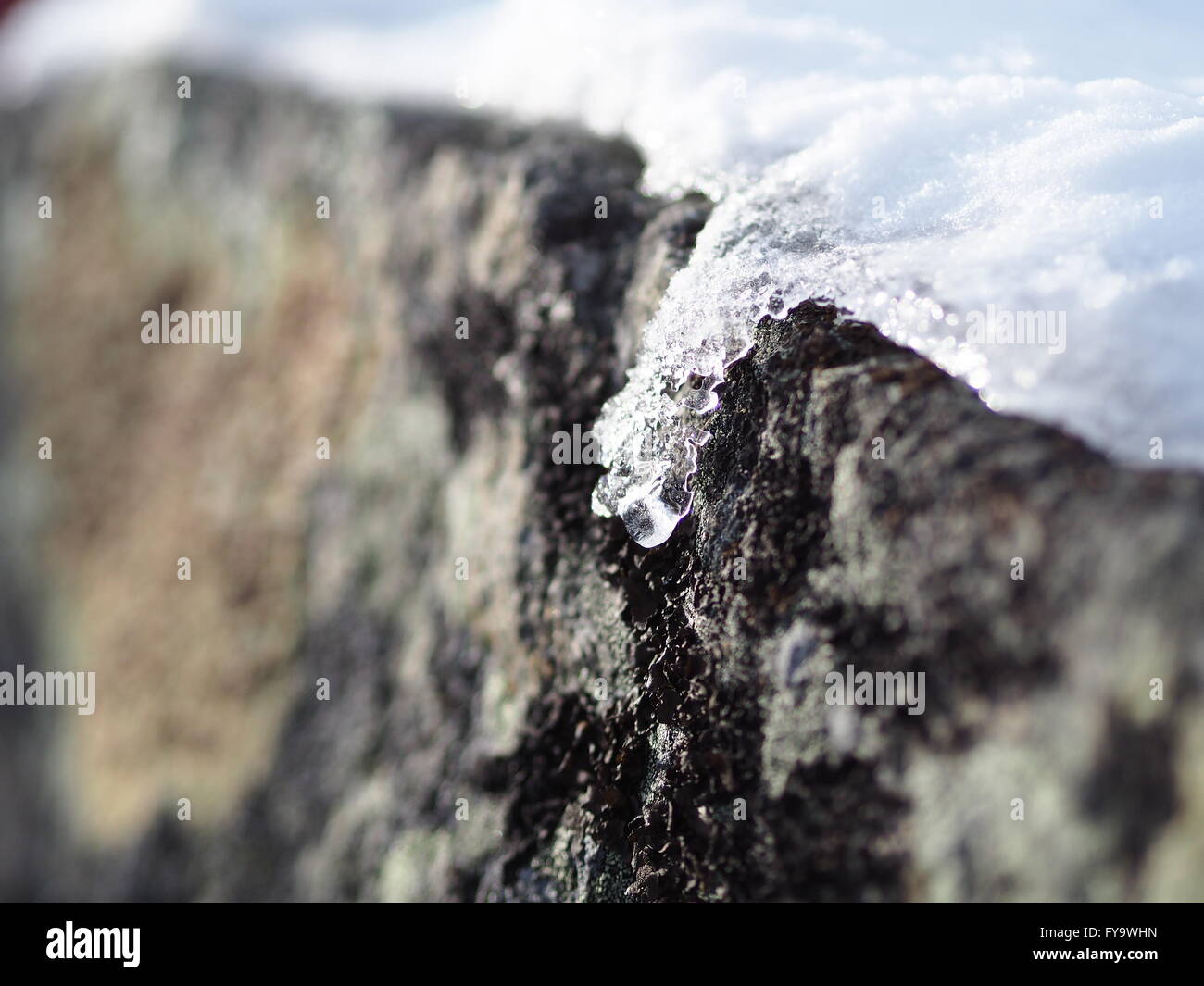 Frozen water close up outside in the nature on a rock. Ice and snow ...