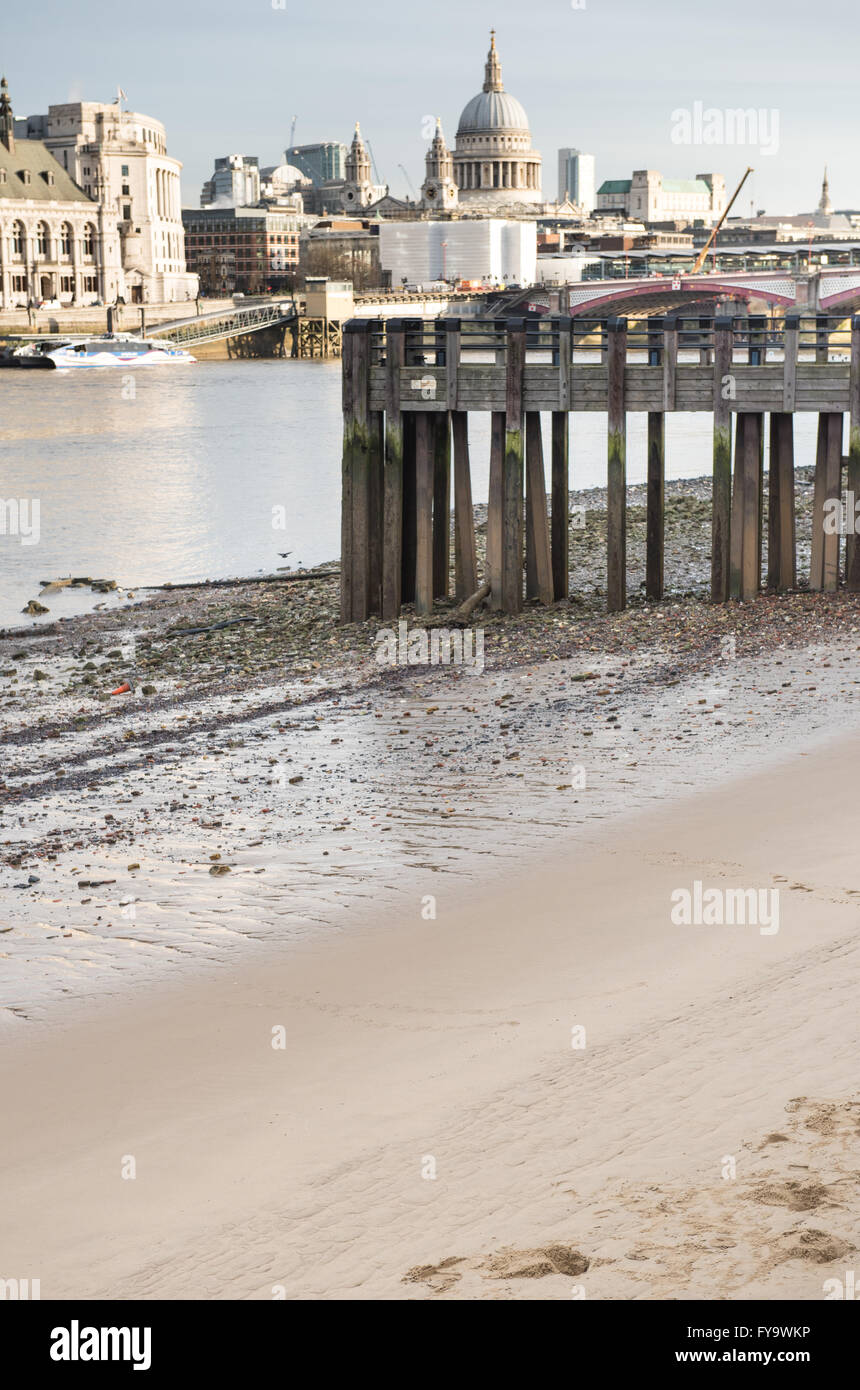 A sandy beach on the banks of the River Thames in London, England with ...