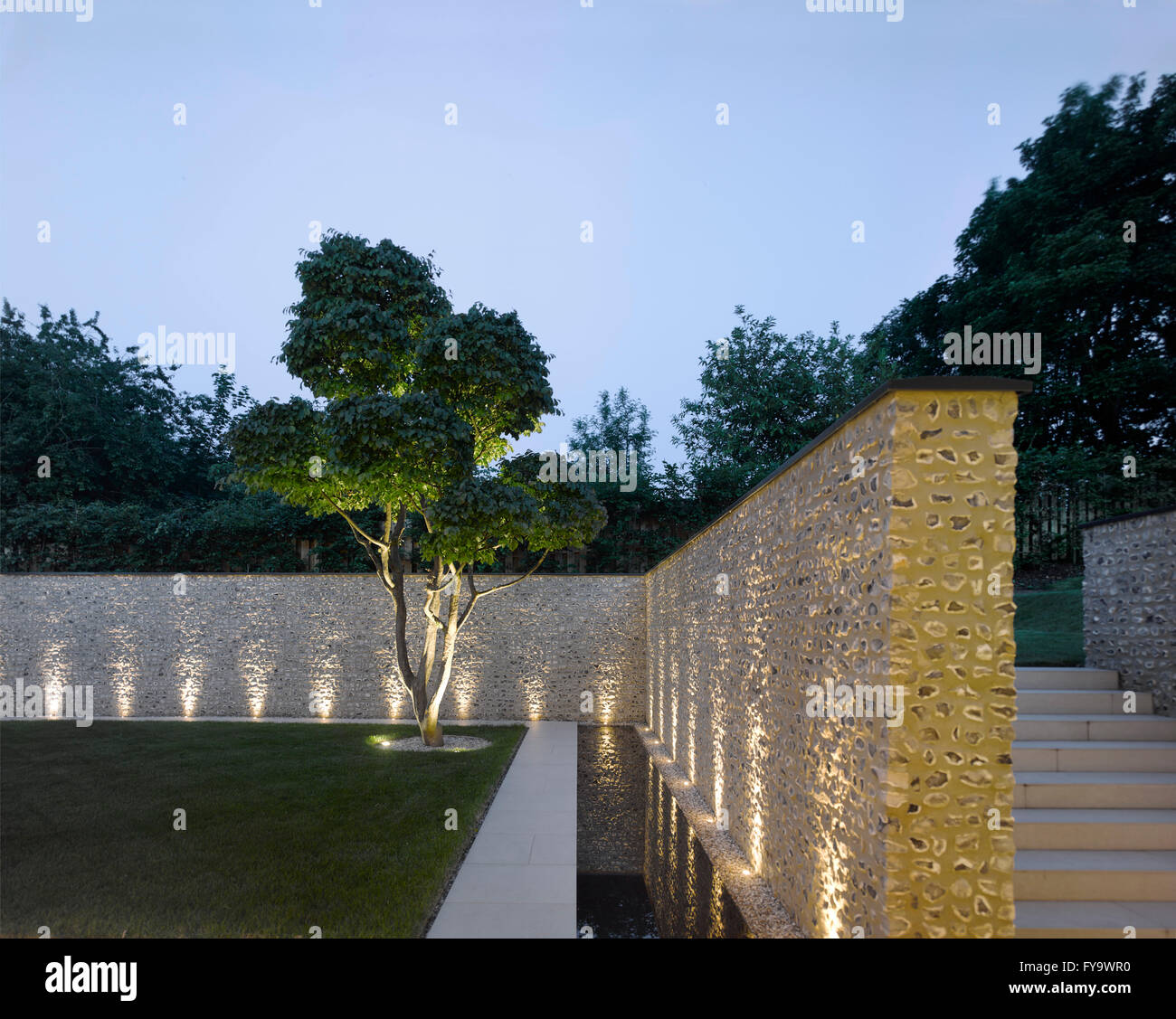 Flint-faced courtyard walls at dusk. Cheeran House, Lower Basildon ...