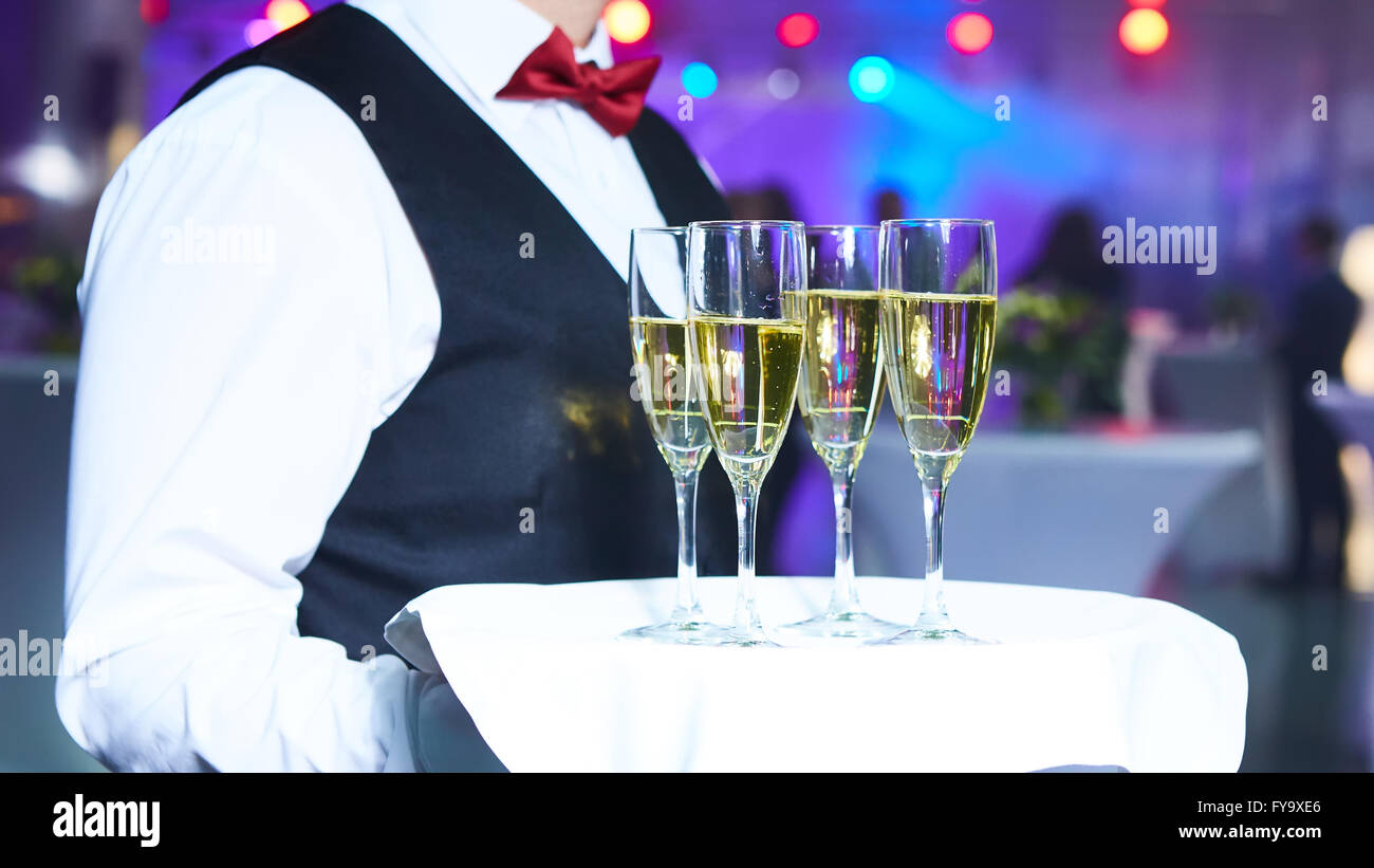 Waiter serving champagne on a tray at party Stock Photo - Alamy