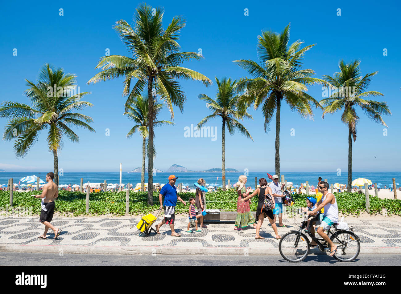 RIO DE JANEIRO - FEBRUARY 28, 2016: Beachgoers pass on the beachfront ...