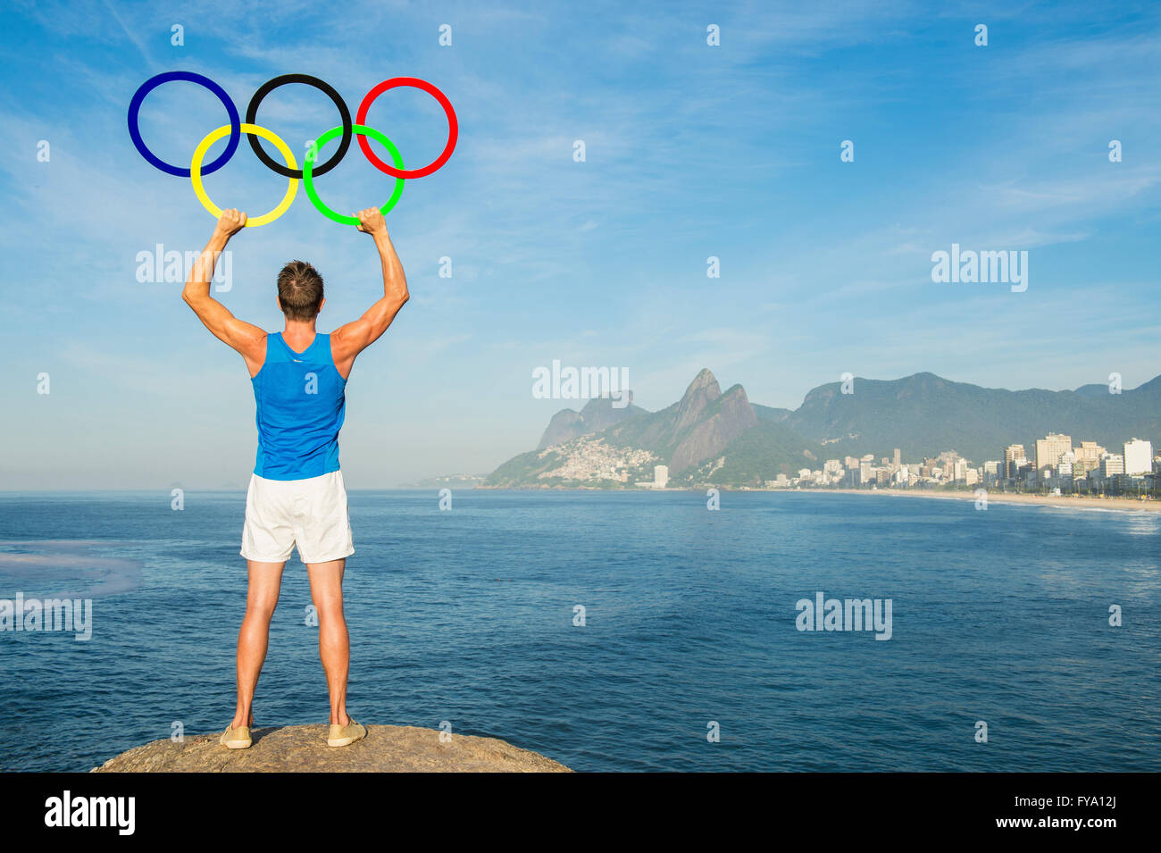 RIO DE JANEIRO - MARCH 27, 2016: Athlete holds Olympic rings standing ...