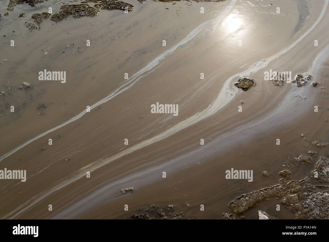 Vibrant colours of a mechanical oil spill on water creating a polluted ...