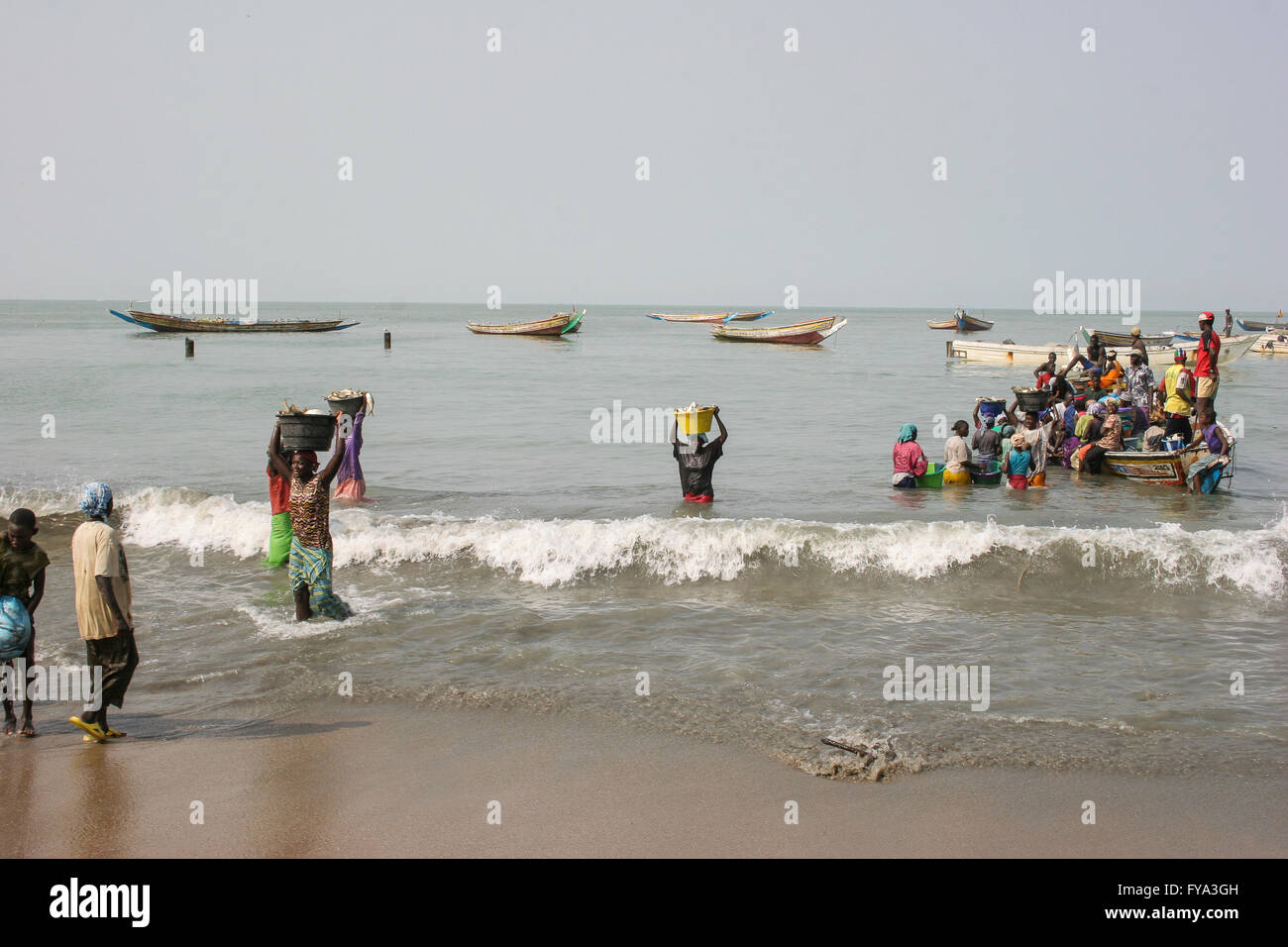 African women carrying buckets on their heads full of fishes from ...