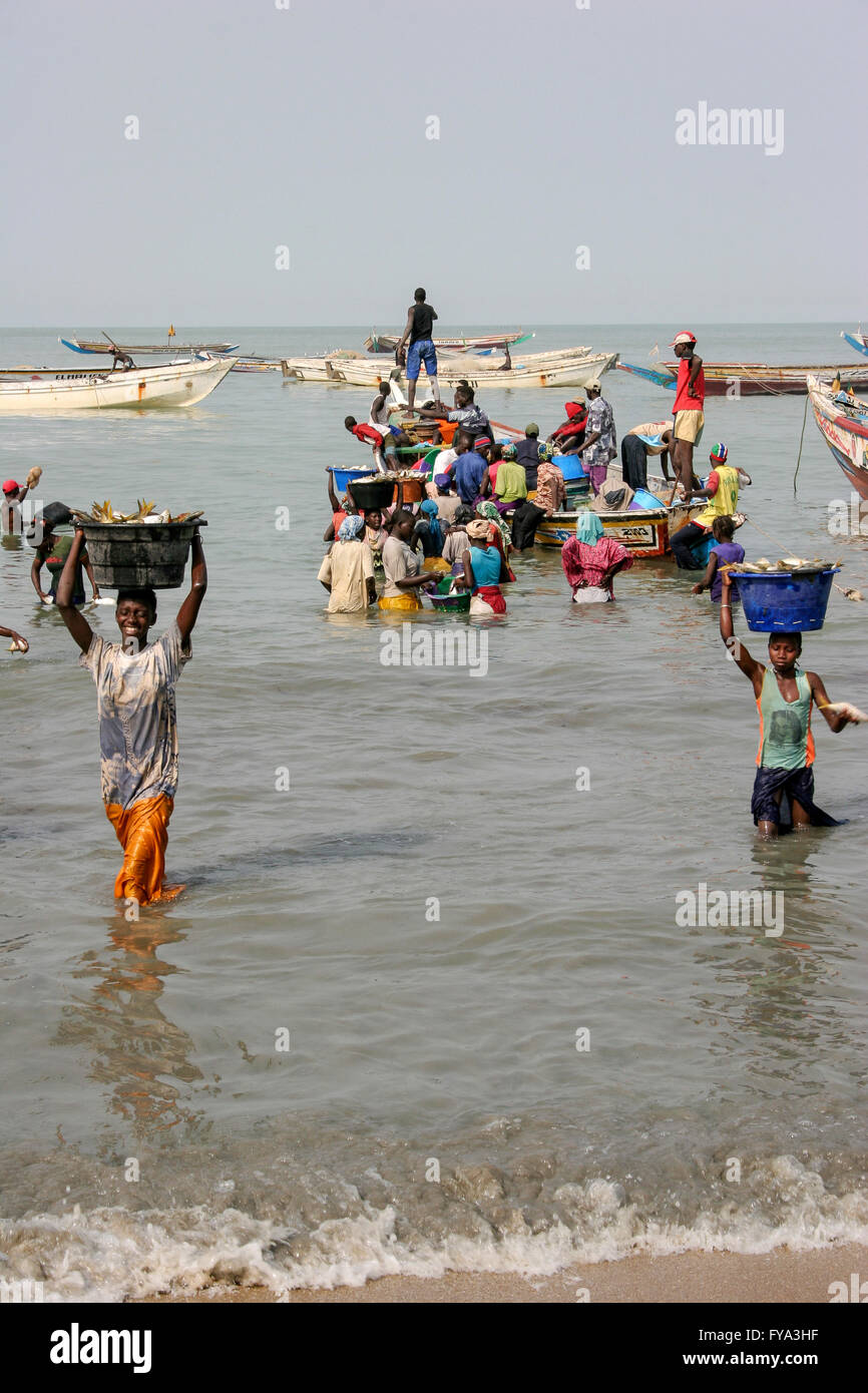 African women carrying buckets on their heads full of fishes from ...