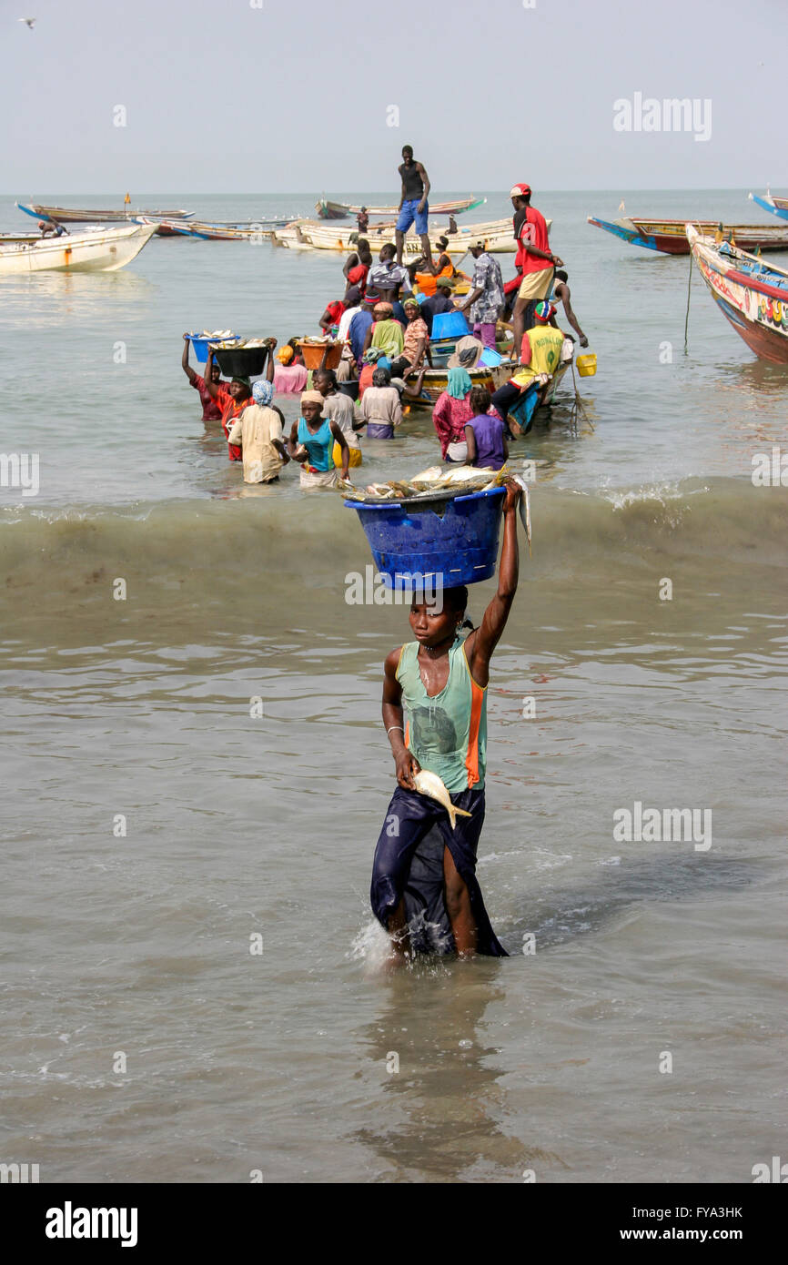 African women carrying buckets on their heads full of fishes from ...