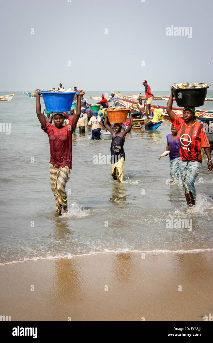 African women carrying buckets on their heads full of fishes from ...