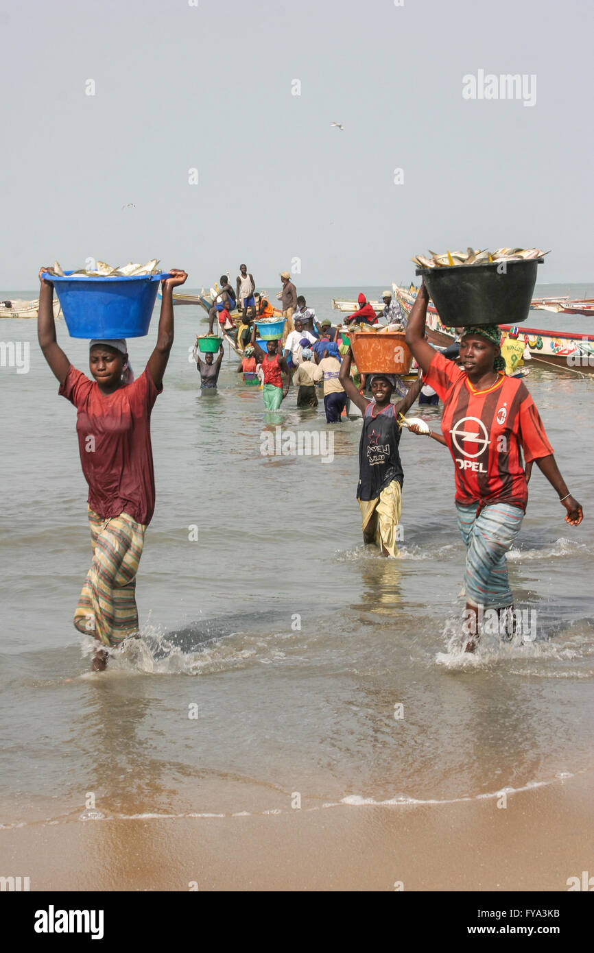 African women carrying buckets on their heads full of fishes from ...