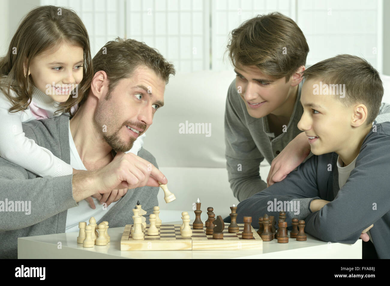 Family playing chess at home Stock Photo - Alamy