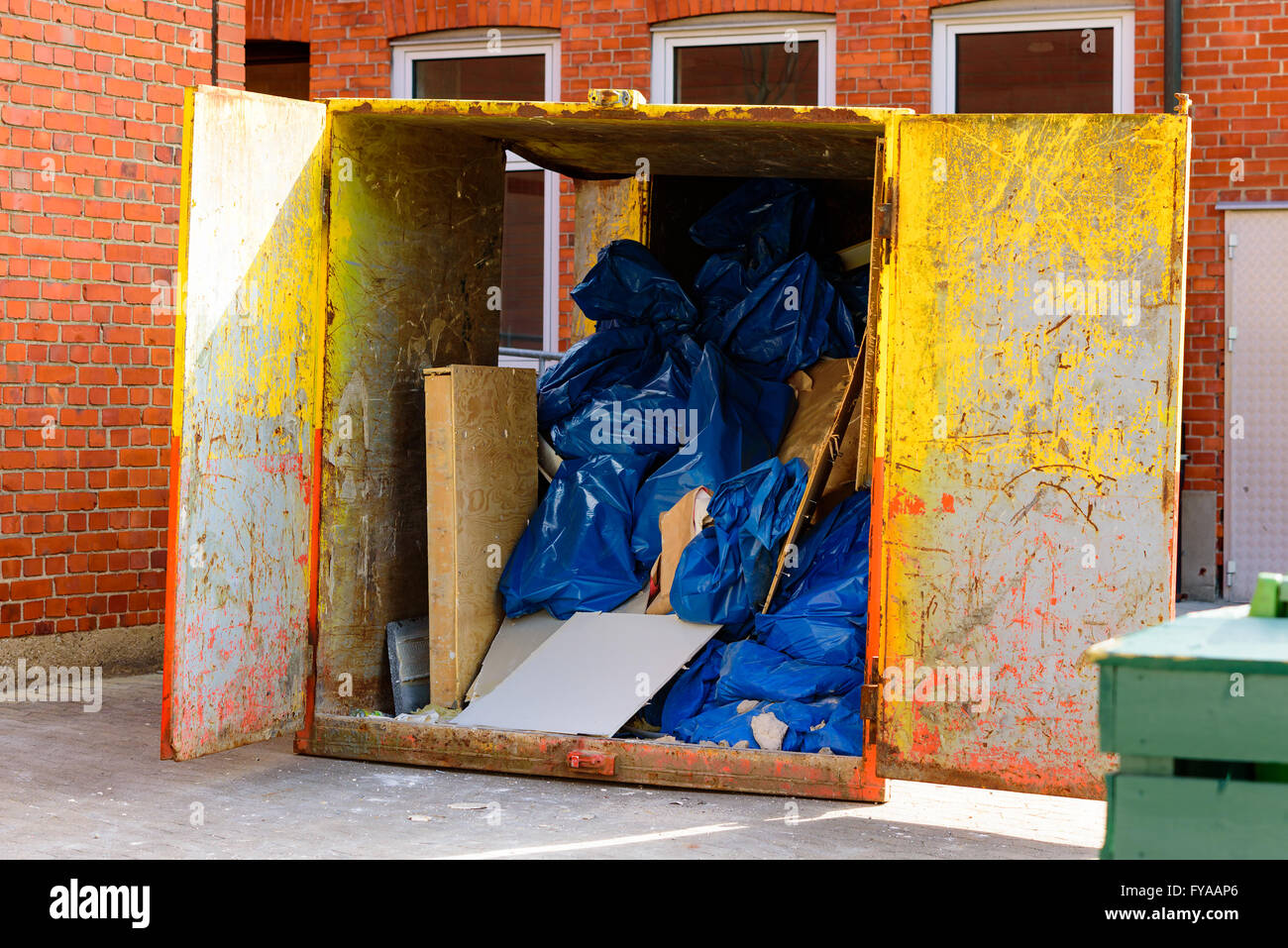 Metal container with open doors showing some trash and debris ...