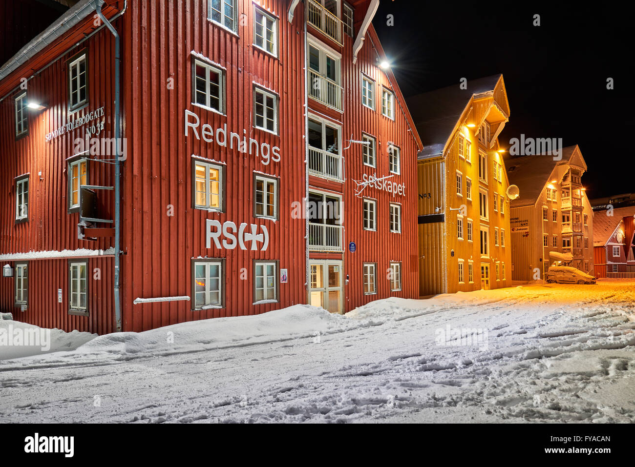 typical coloured wooden buildings in harbour of Tromso, night shot with ...