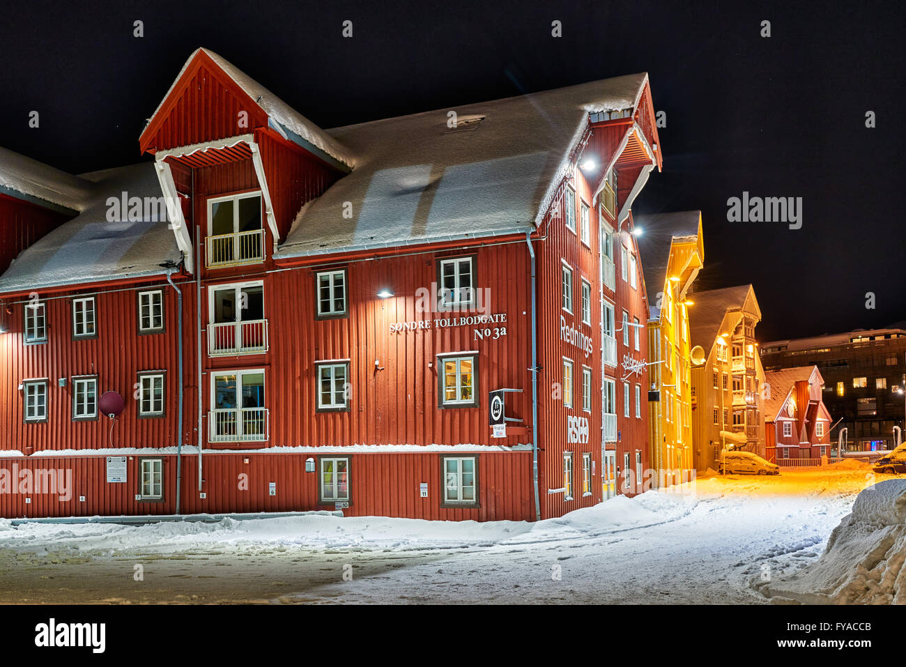 typical coloured wooden buildings in harbour of Tromso, night shot with ...