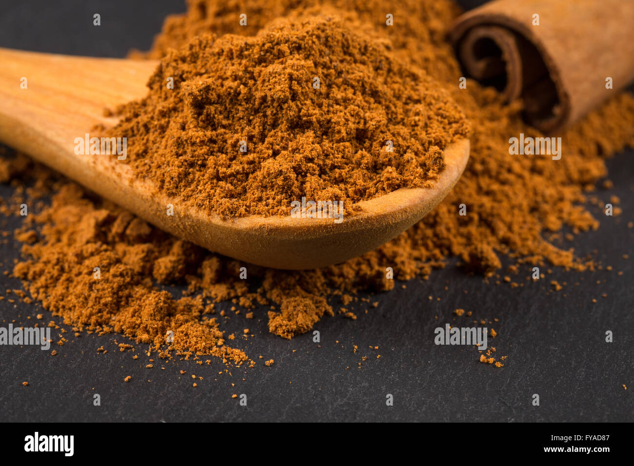cinnamon sticks with powder on dark stone plate Stock Photo - Alamy
