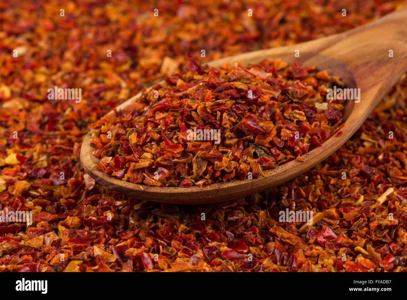 Crushed red chili pepper and wooden spoon Stock Photo - Alamy