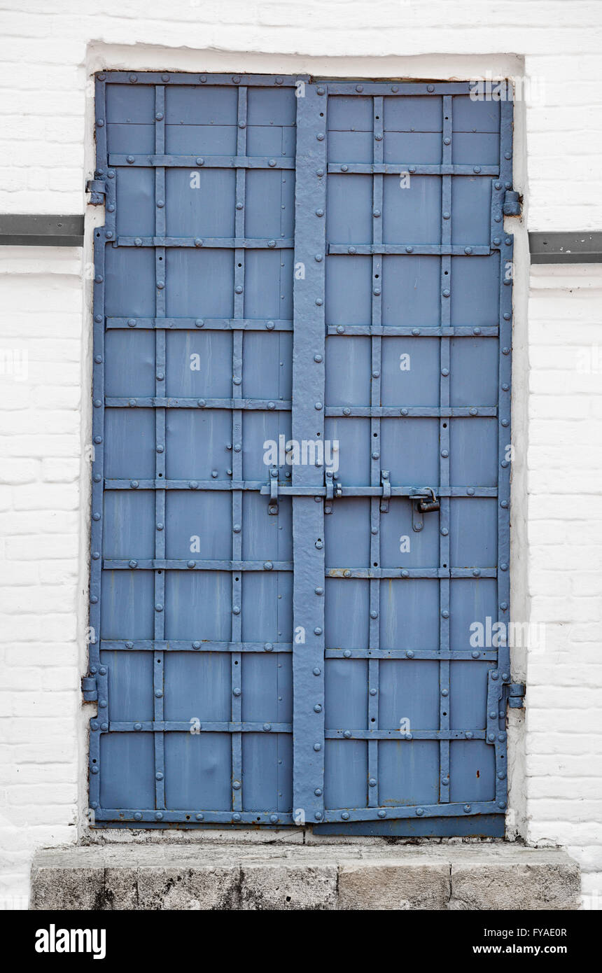 Black painted, reinforced iron door, held together with rivets and ...