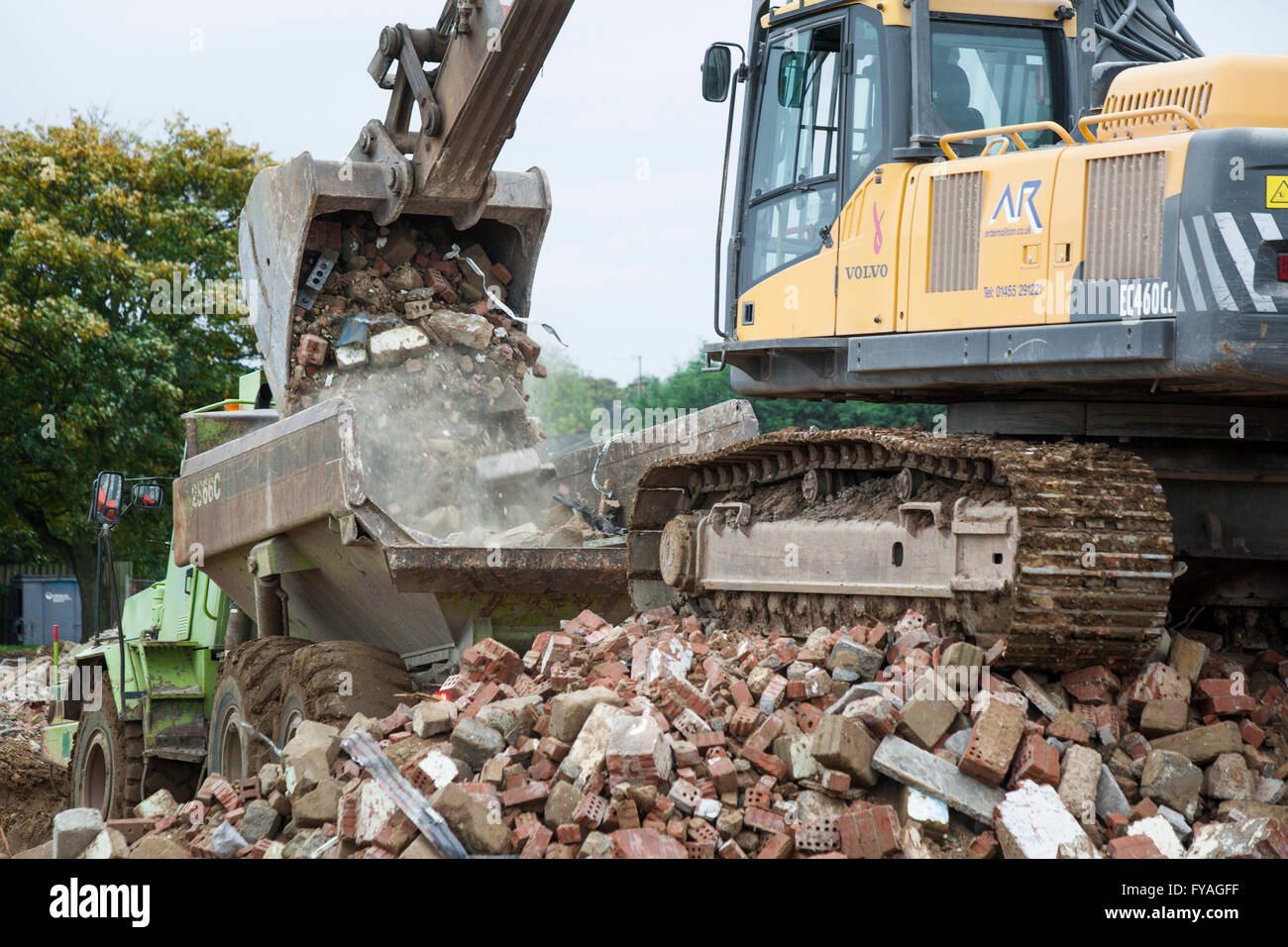 A demolition site in UK. Heavy plant machines demolishing an old school ...