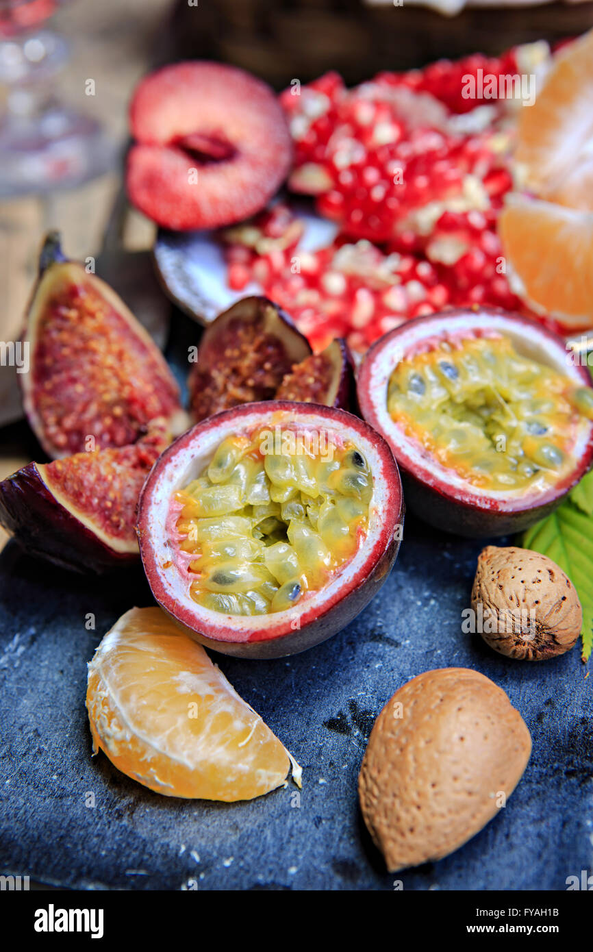 a plate with passion fruit, nuts, fig, mandarin and pomegranate Stock ...