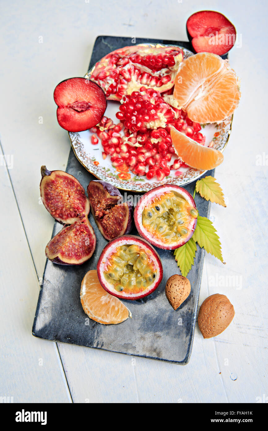 a plate with passion fruit, nuts, fig, mandarin and pomegranate Stock ...
