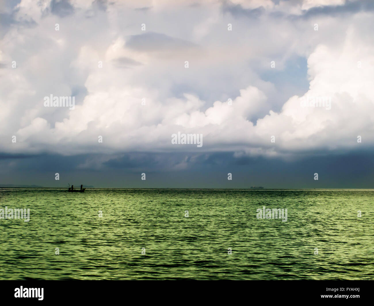 Fishing boat and green sea on horizon line on blue sea Stock Photo - Alamy