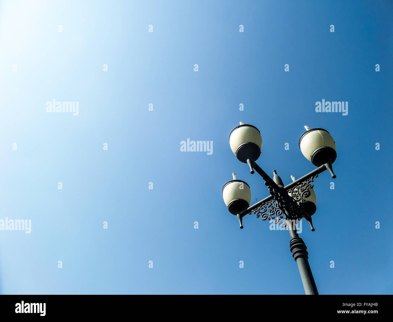 Street light post with four lamps and blue sky background Stock Photo ...