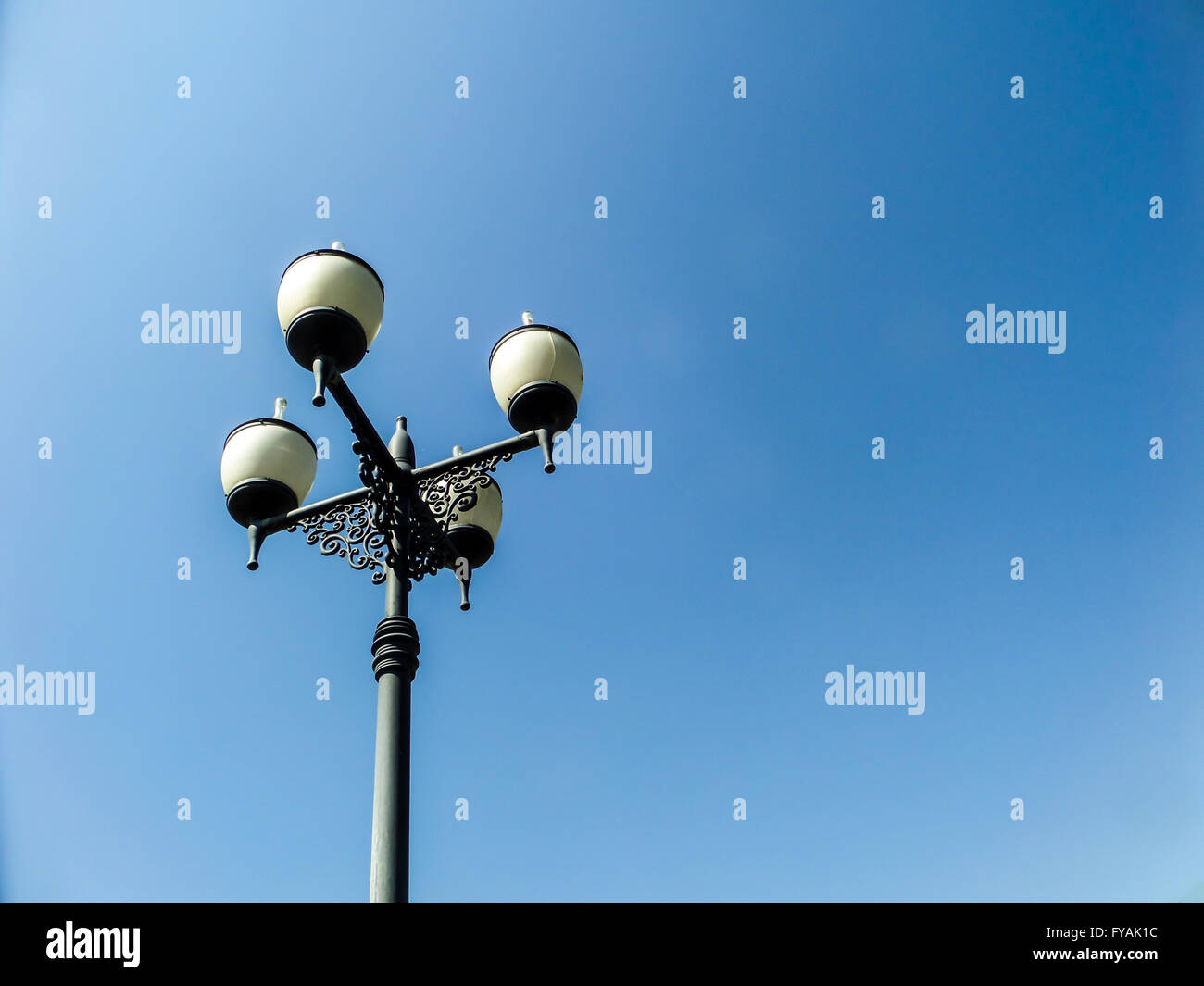 Street light post with four lamps and blue sky background Stock Photo ...