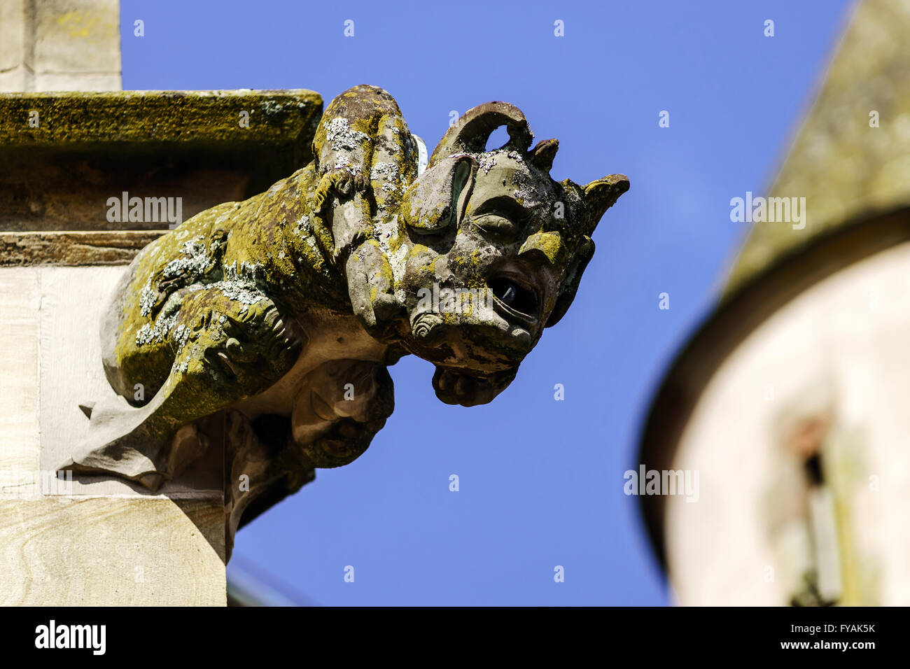 Gargoyle on a gothic cathedral, detail of a tower on blue sky ...