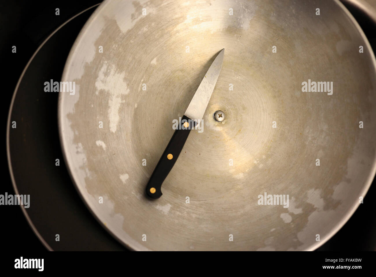 Knife inside the lid of a wok Stock Photo - Alamy