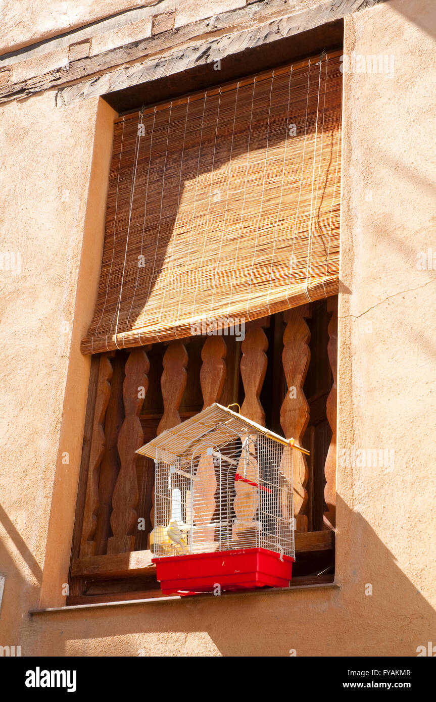 Window with a canary in a cage. Hervas, Caceres province, Extremadura ...