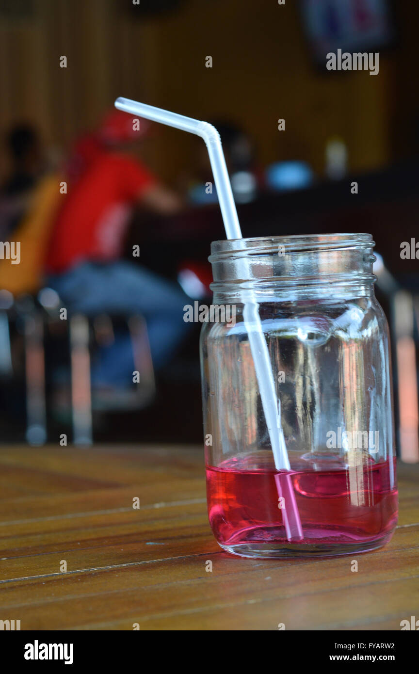 drinks strawberry syrup on the wooden table with blurry cafe background ...