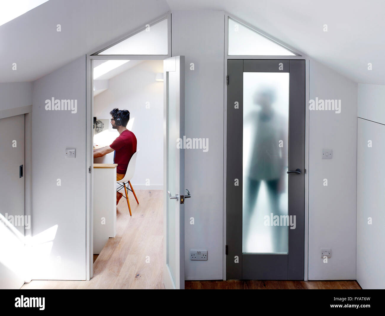 Looking into home office, person at work at the desk, shadow behind ...