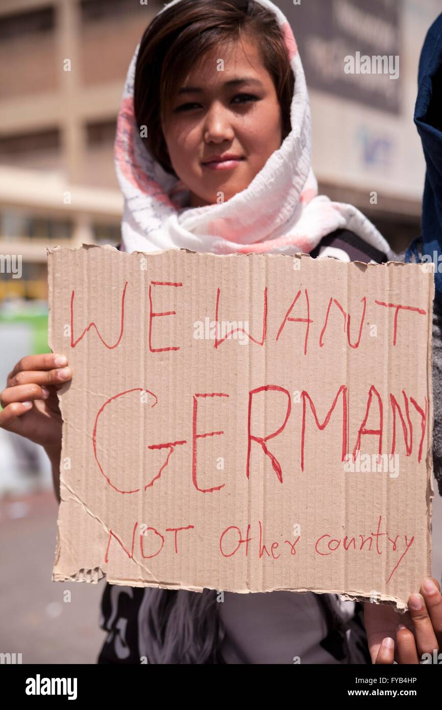 Afghan refugee girl at habour of Piraeus. Afghan girl with paper "We ...