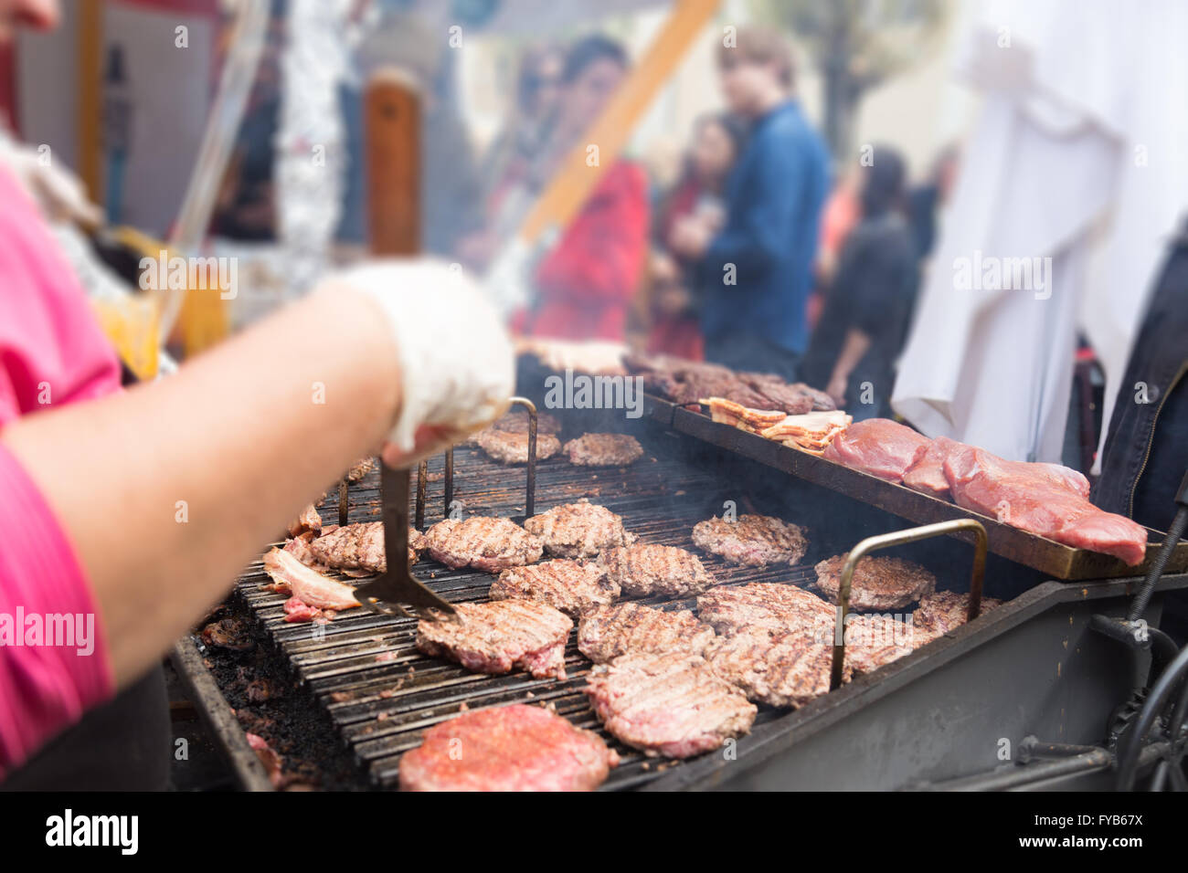 Beef burgers being grilled on food stall grill Stock Photo - Alamy