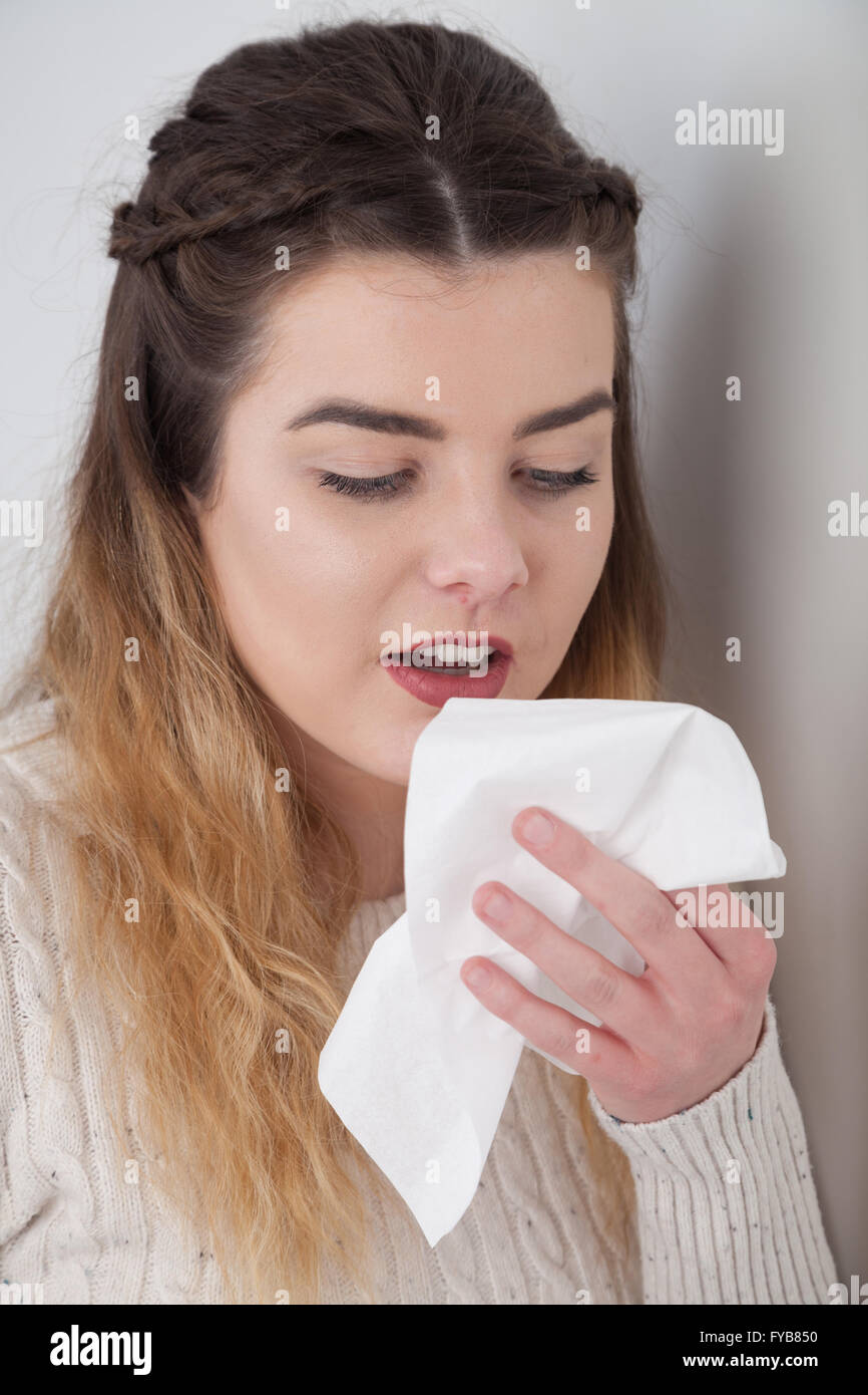 Young woman about to sneeze into a paper handkerchief Stock Photo - Alamy