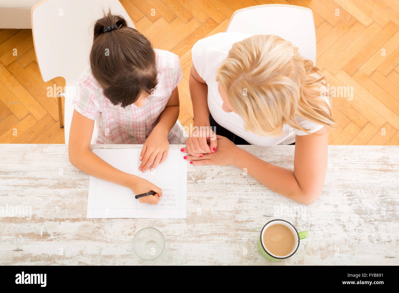 A mother helping her daughter with the homework seen from above Stock ...