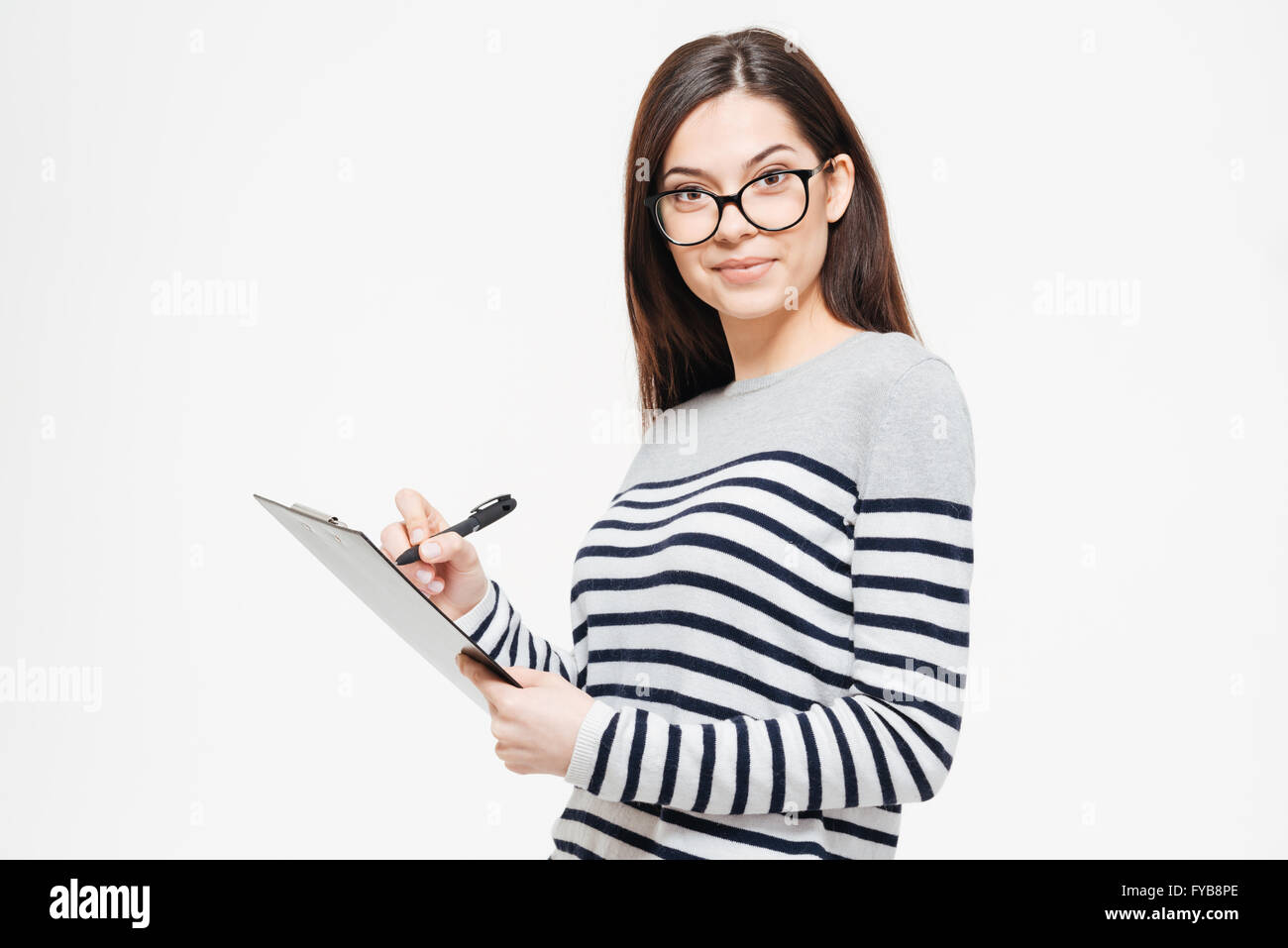 Happy woman writing notes in clipboard and looking at camera isolated ...