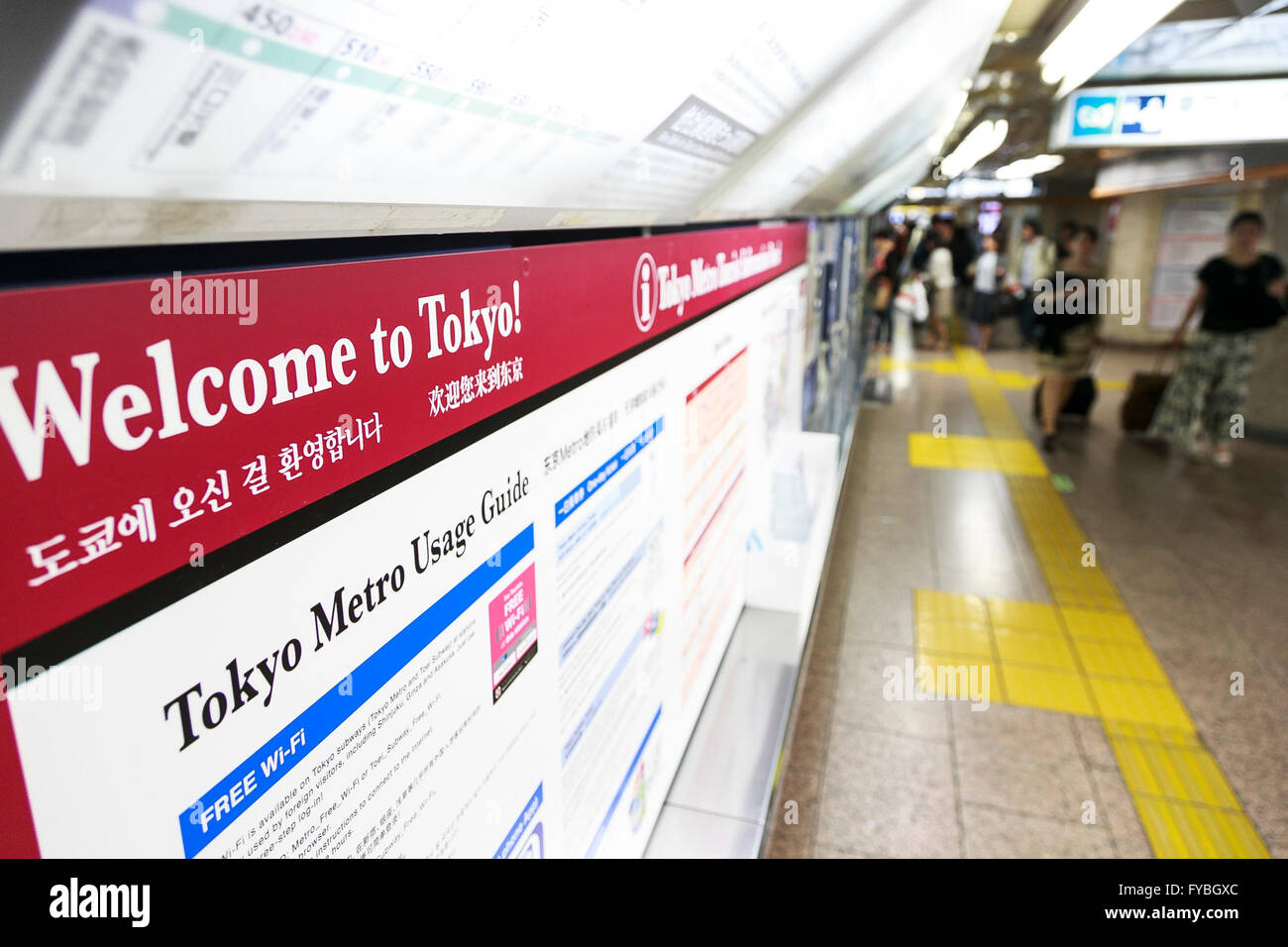 Foreign tourists walk past a Tokyo Metro Tourist Information Board in ...