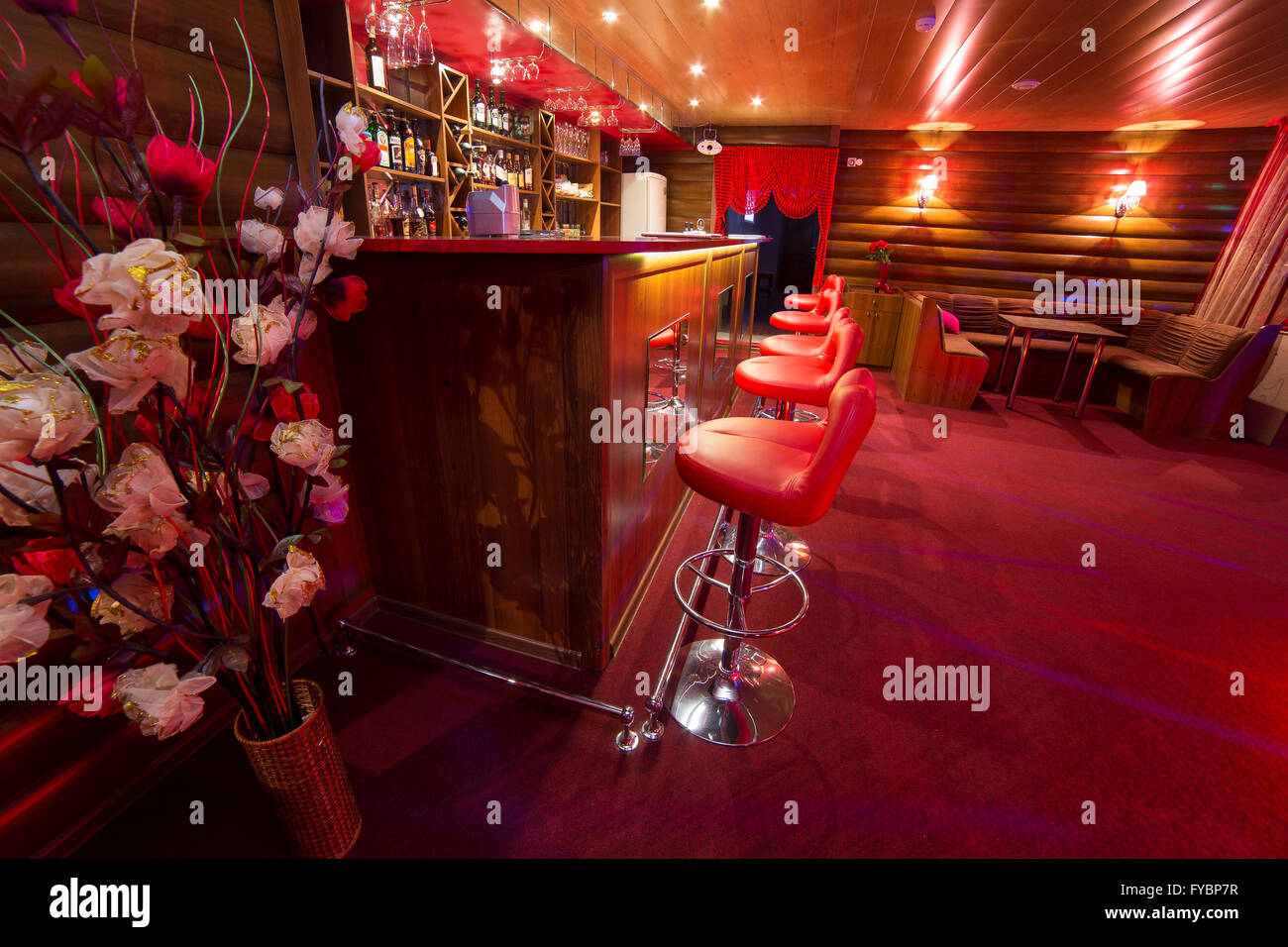 Interior of a bar designed in wood with red light and flowers Stock ...